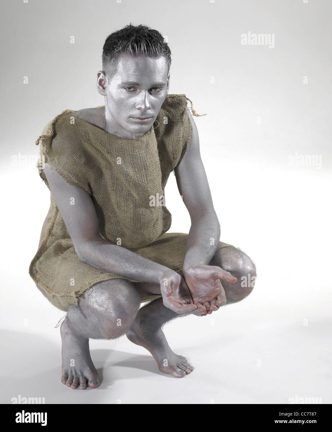 begging poor man dressed in a gunnysack. Studio photography in light ...