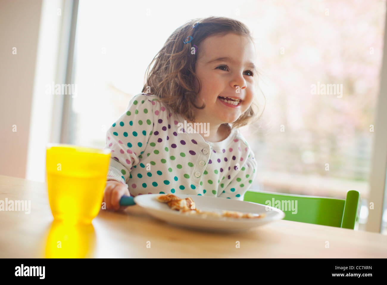 Girl Eating at Kitchen Table Stock Photo - Alamy