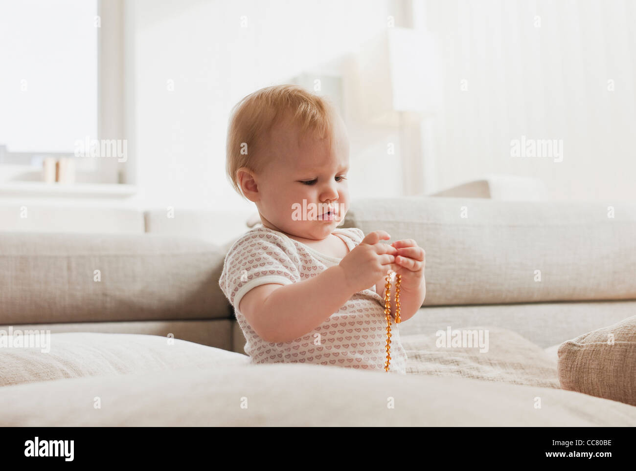 Baby Girl Playing with Beads Stock Photo - Alamy