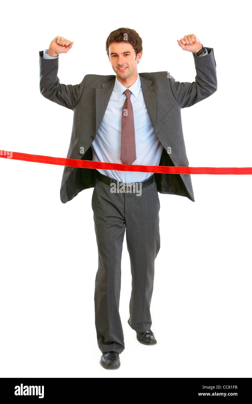 Full length portrait of pleased businessman crossing finish line ...