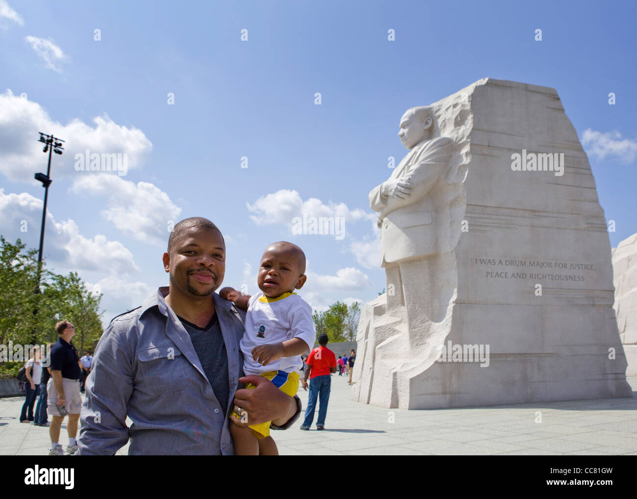 A young African-American father holding up his son at the Martin Luther ...