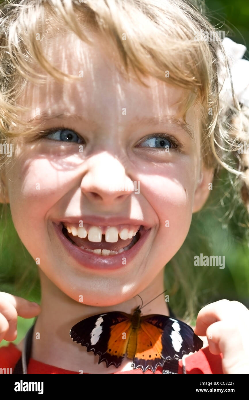 Happy child with butterfly on neck Stock Photo - Alamy