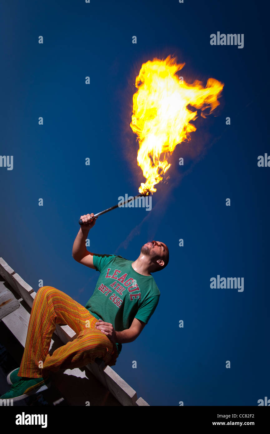 Male fire eater performing on the beach pier, Alcudia at dusk, Majorca ...