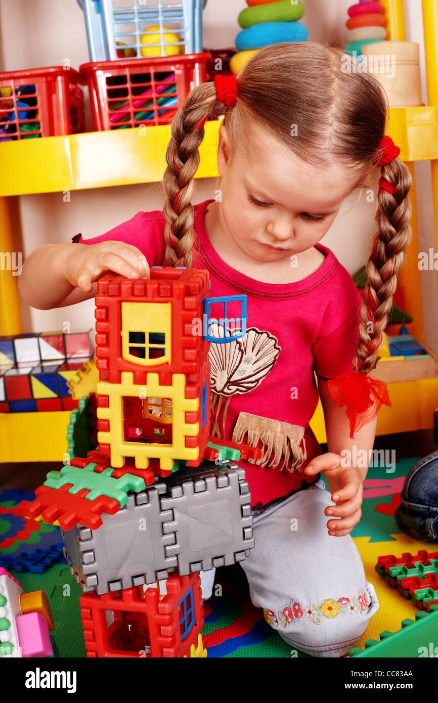 Child with puzzle, block and construction set in playroom Stock Photo ...