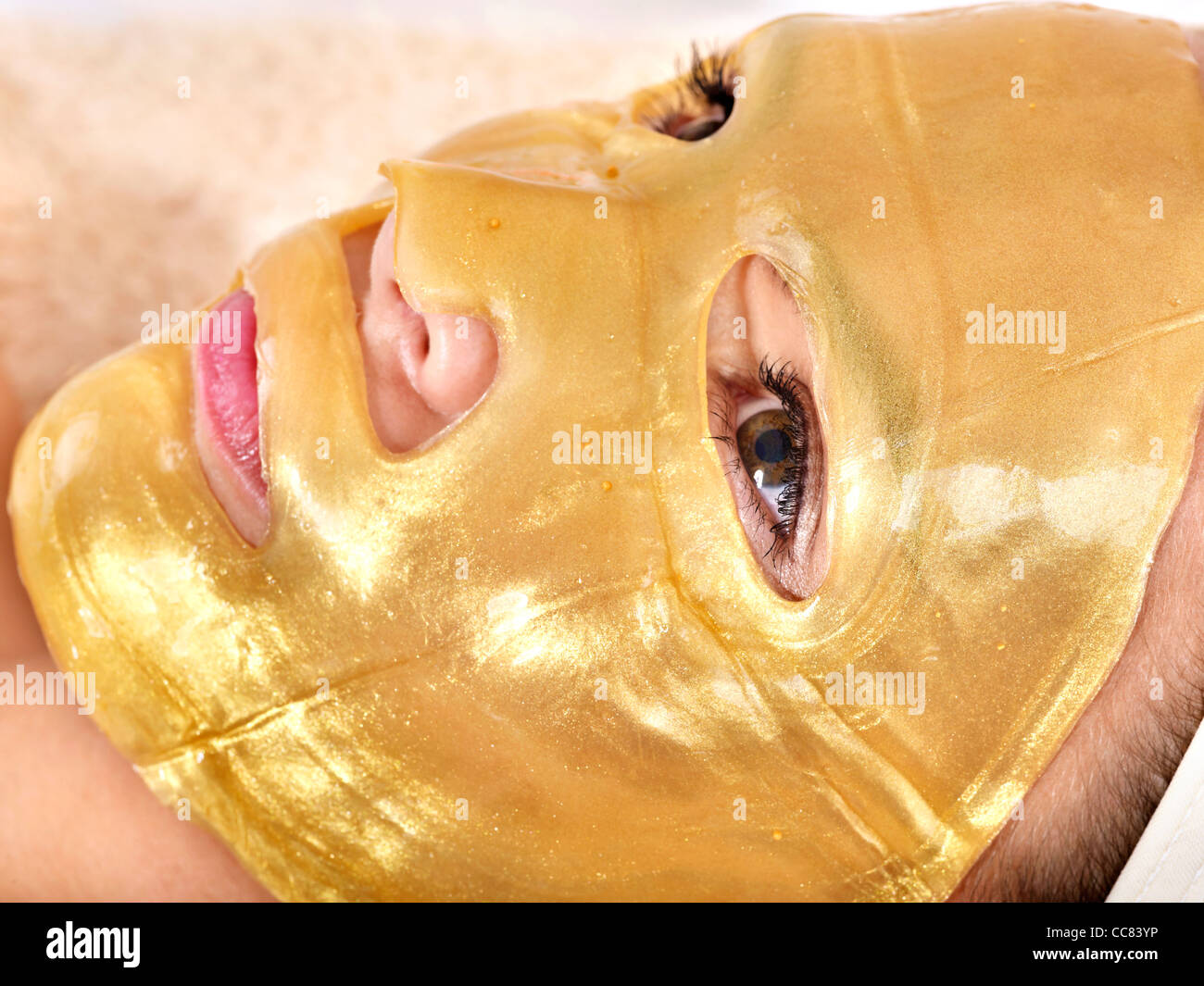 Young woman with gold facial mask Stock Photo - Alamy