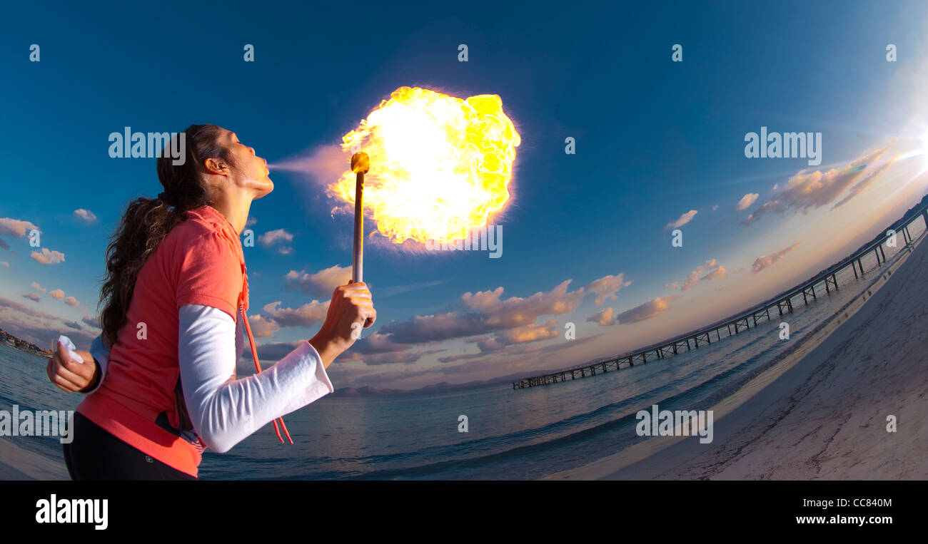 Female fire breather performing on Alcudia beach at dusk Stock Photo ...