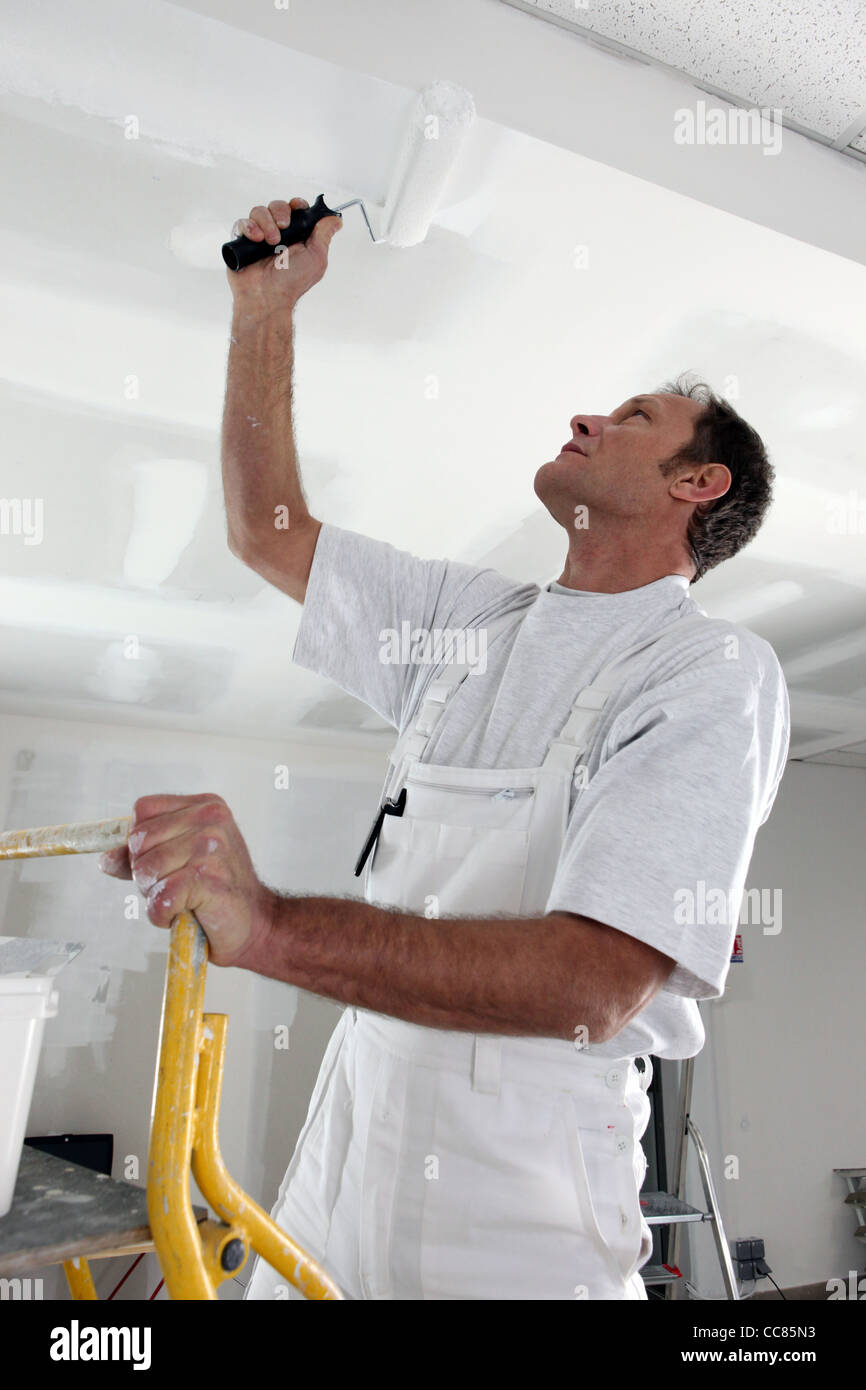 Man painting ceiling with roller Stock Photo - Alamy