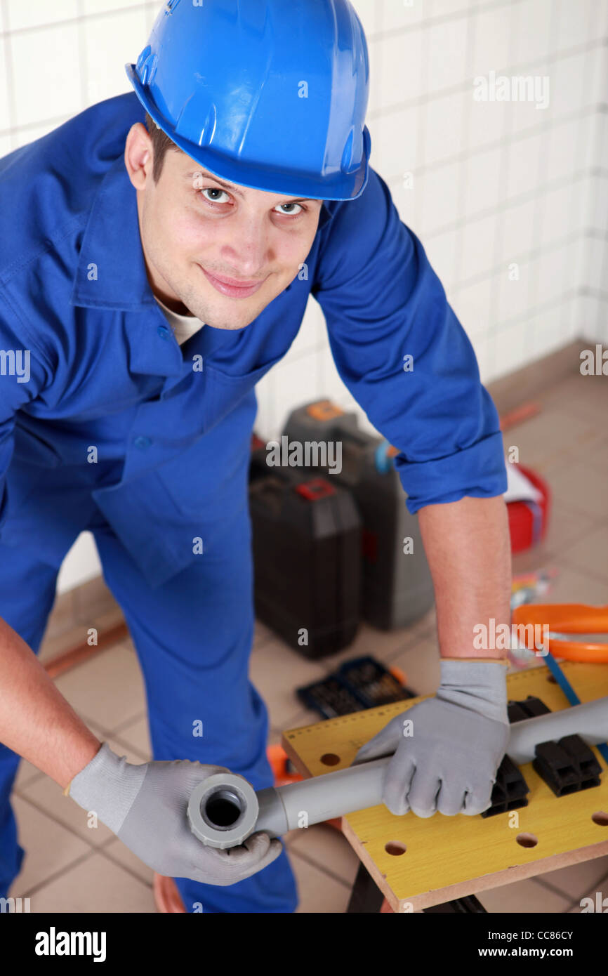 Plumber preparing pipe on work bench Stock Photo - Alamy