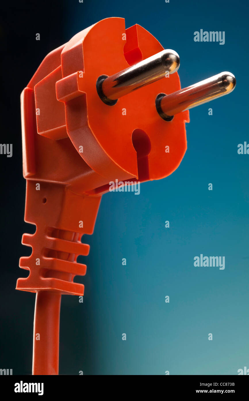 orange electric plug with cable on blue background Stock Photo - Alamy