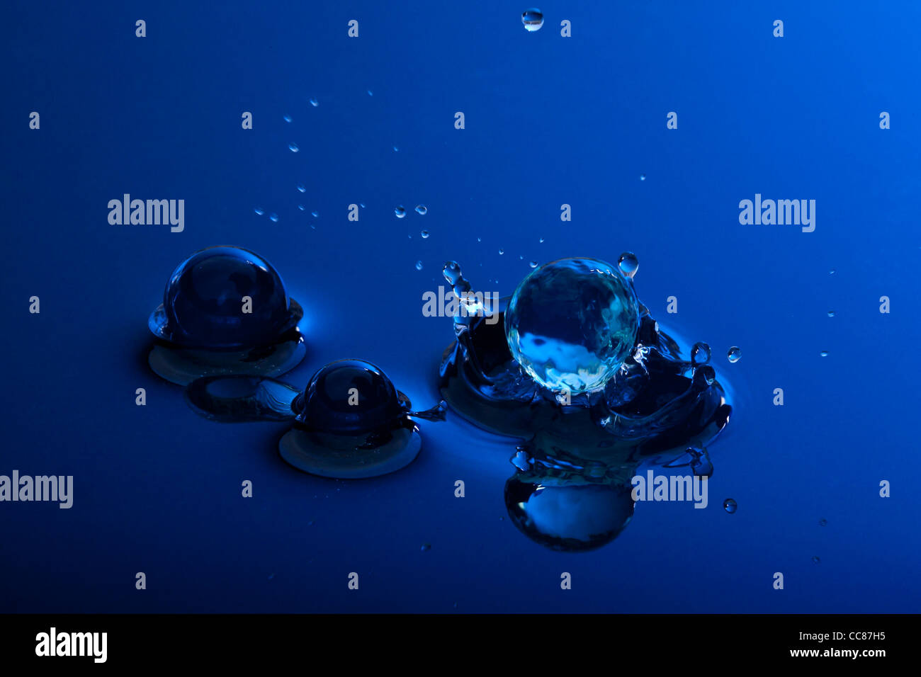 falling water drops splashing in water in blue light Stock Photo - Alamy