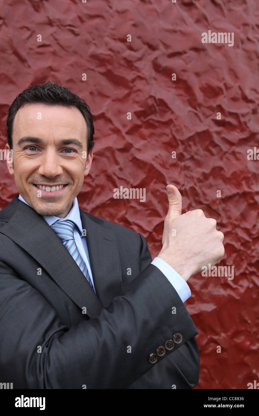 Businessman giving the thumbs sign Stock Photo - Alamy