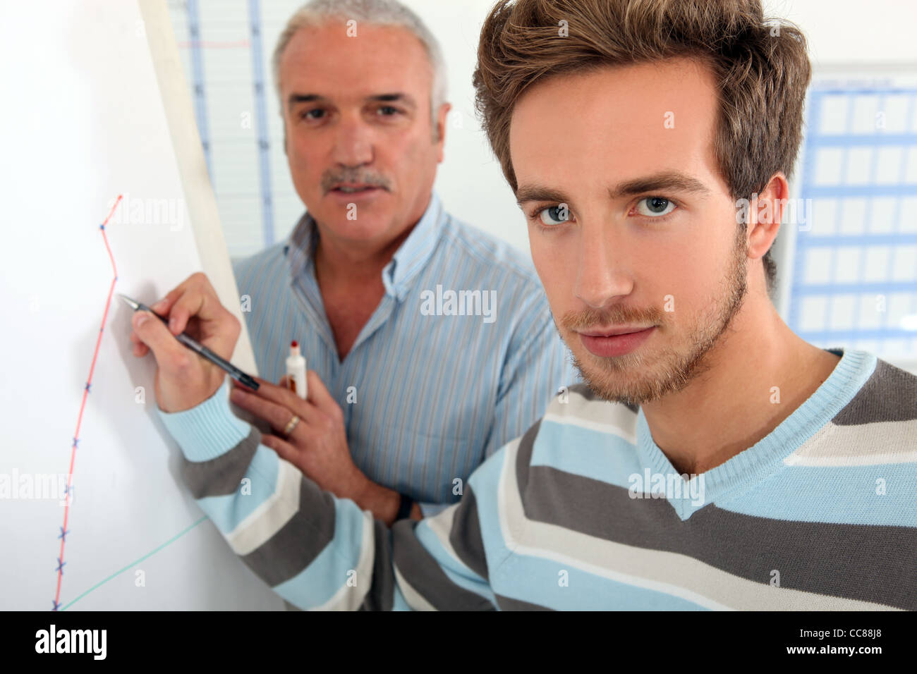 Young man writing on whiteboard Stock Photo - Alamy