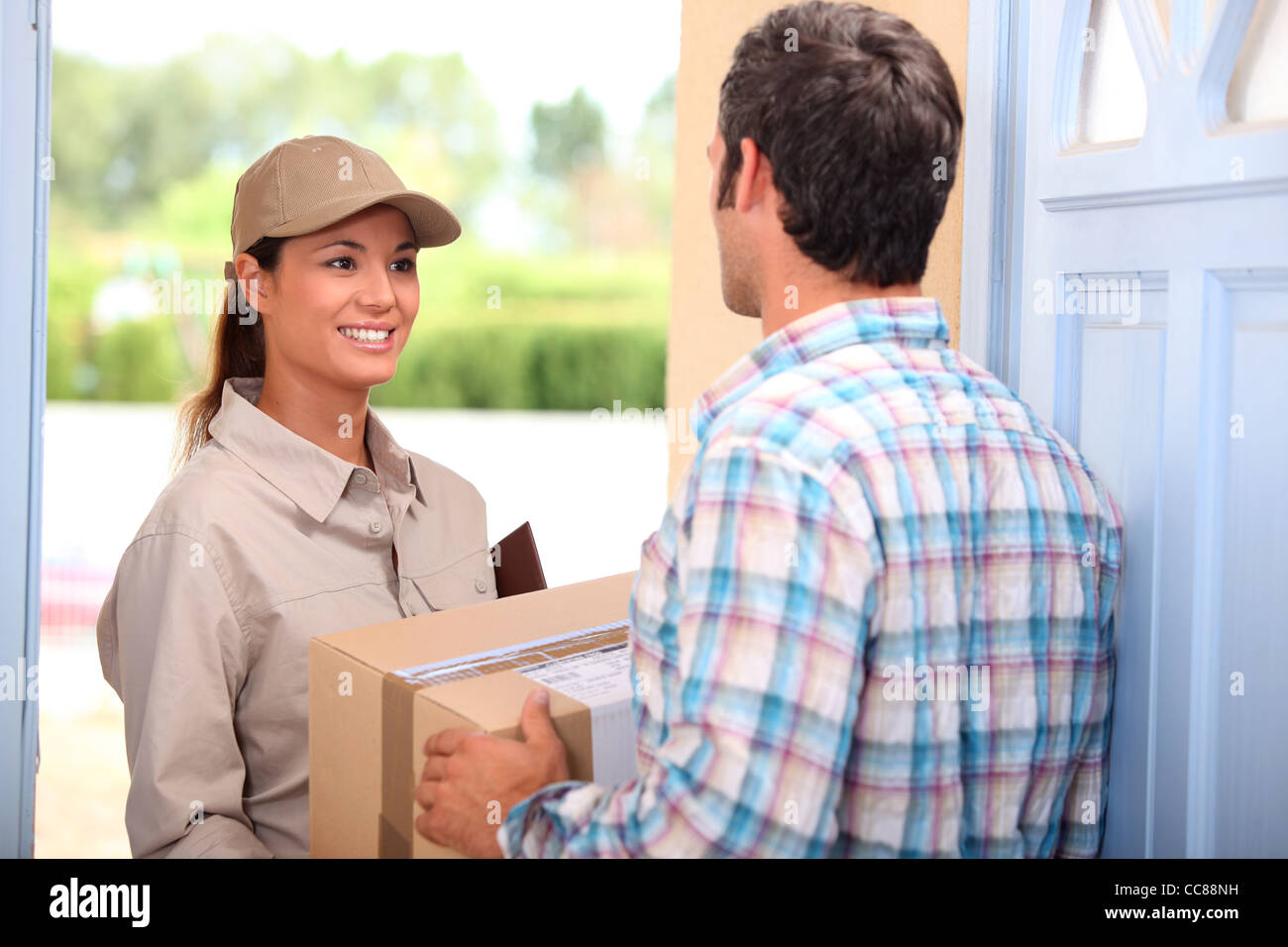 Woman delivering parcel Stock Photo - Alamy