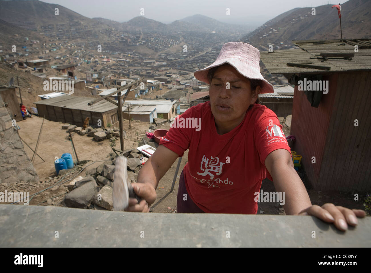 A construction worker builds a new wall along a hillside in Lima, Peru ...