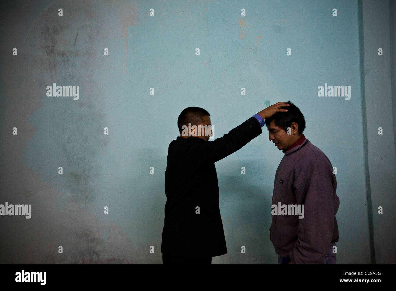 A pastor prays over a parishioner at a church in Lima, Peru, South ...