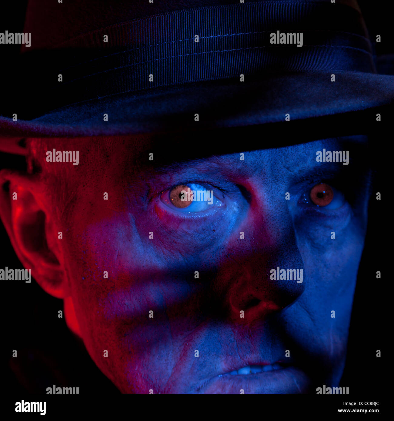 man in hat staring at camera lit by blue and red light Stock Photo - Alamy