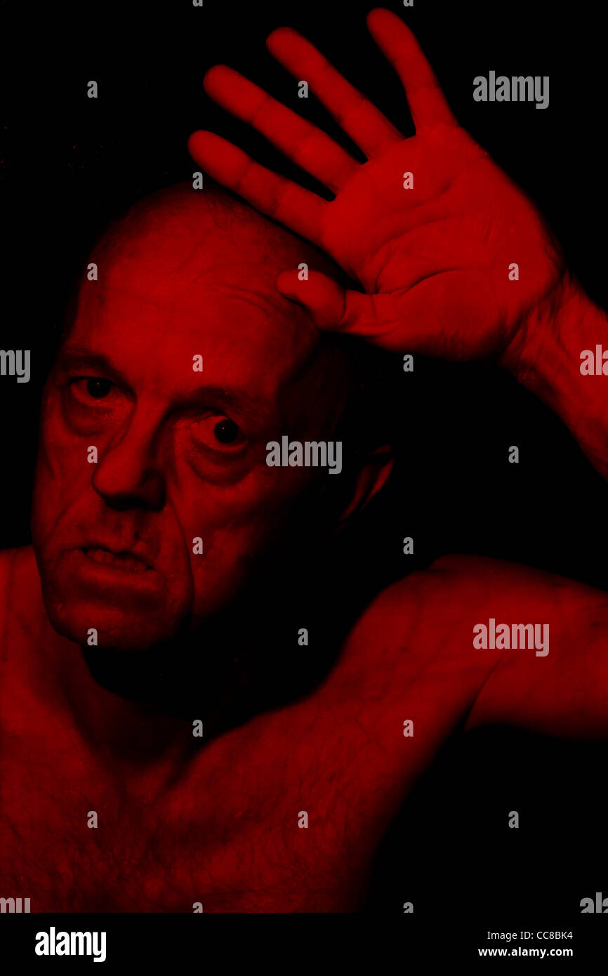 Man drenched in red light staring at the camera Stock Photo - Alamy