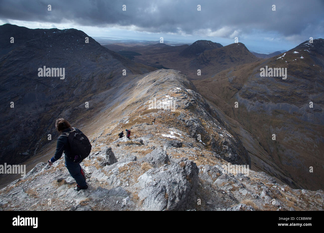 Walker descending the narrow ridge from Bencollaghduff to Maumina ...