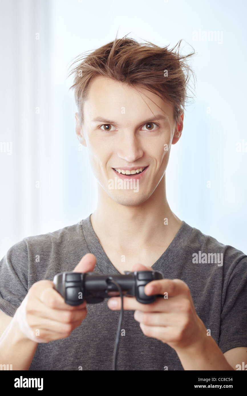 Man playing computer game and using joystick in his room Stock Photo ...