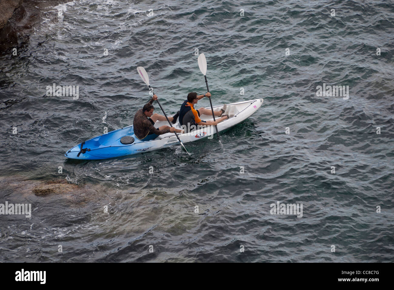 Two men paddling a canoe near Deia Majorca Stock Photo - Alamy