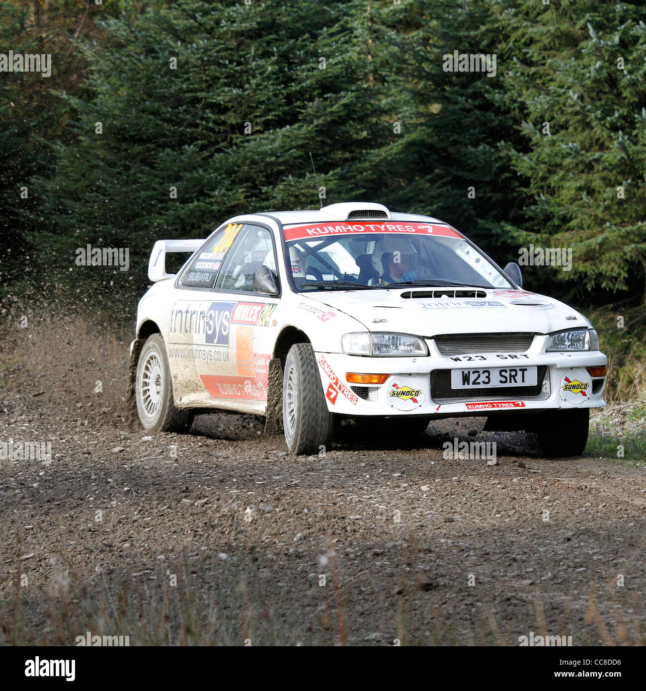 gravel sprays from a rally cars wheels as it passes Stock Photo - Alamy
