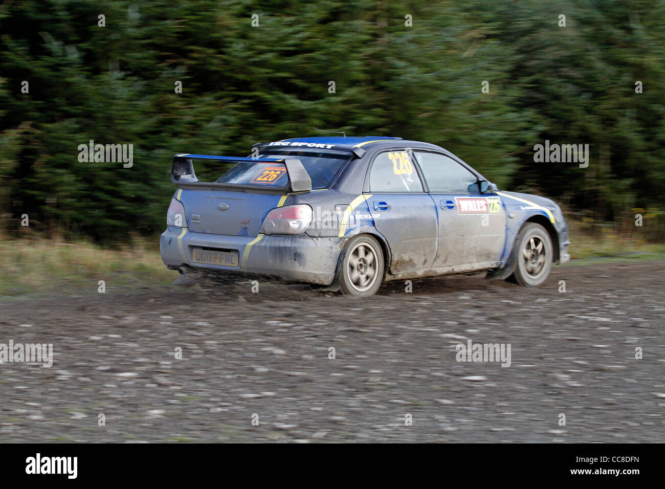 gravel sprays from a rally cars wheels as it passes Stock Photo - Alamy