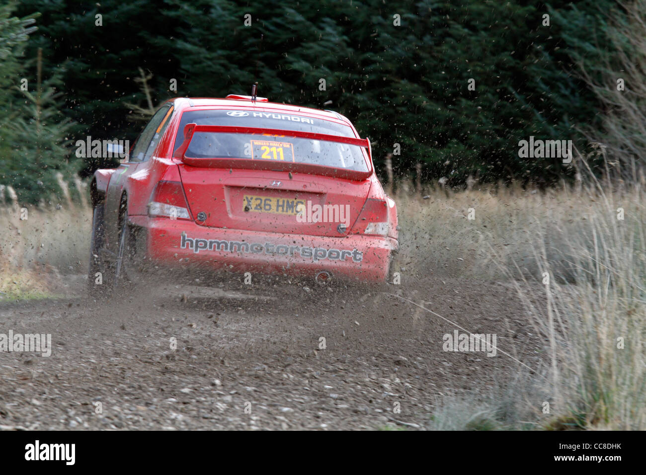 gravel sprays from a rally cars wheels as it passes Stock Photo - Alamy