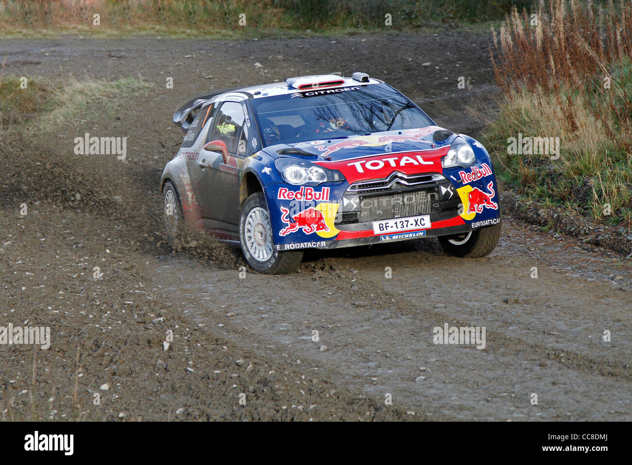 gravel sprays from a rally cars wheels as it passes Stock Photo - Alamy