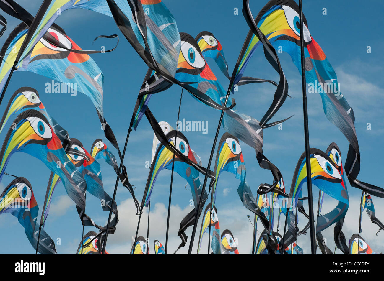 Flags representing birds, flying against a blue sky, with some cloud ...