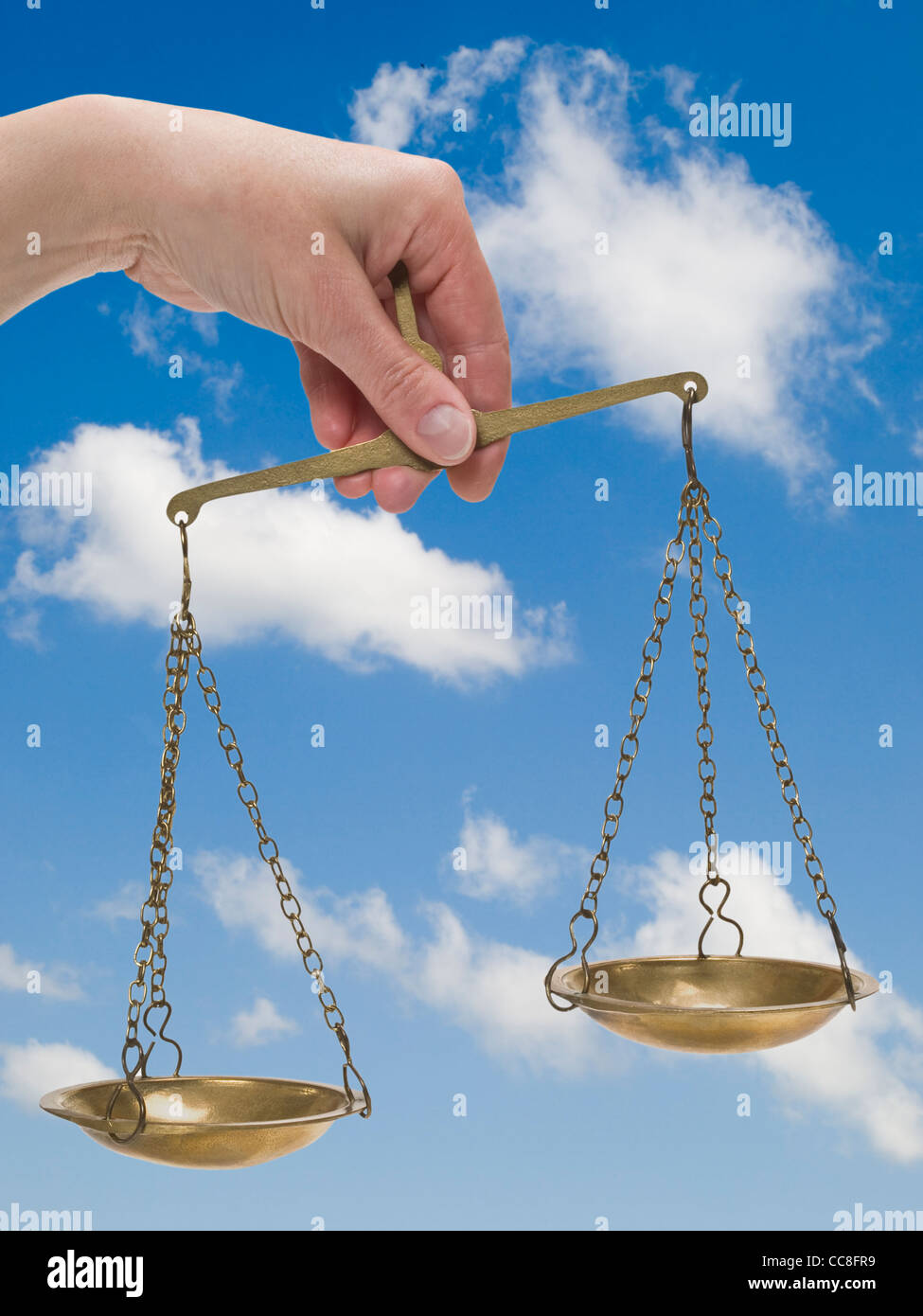 a balance is hand-held, sky is the background Stock Photo - Alamy