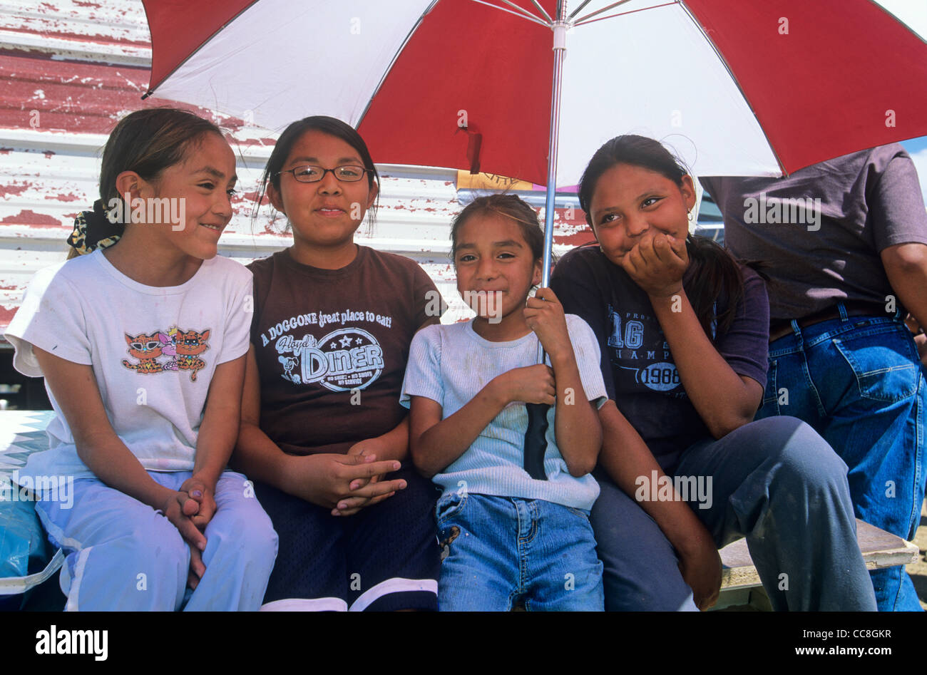 Girls watch horse races from under umbrella, during Yazzie Benefit ...