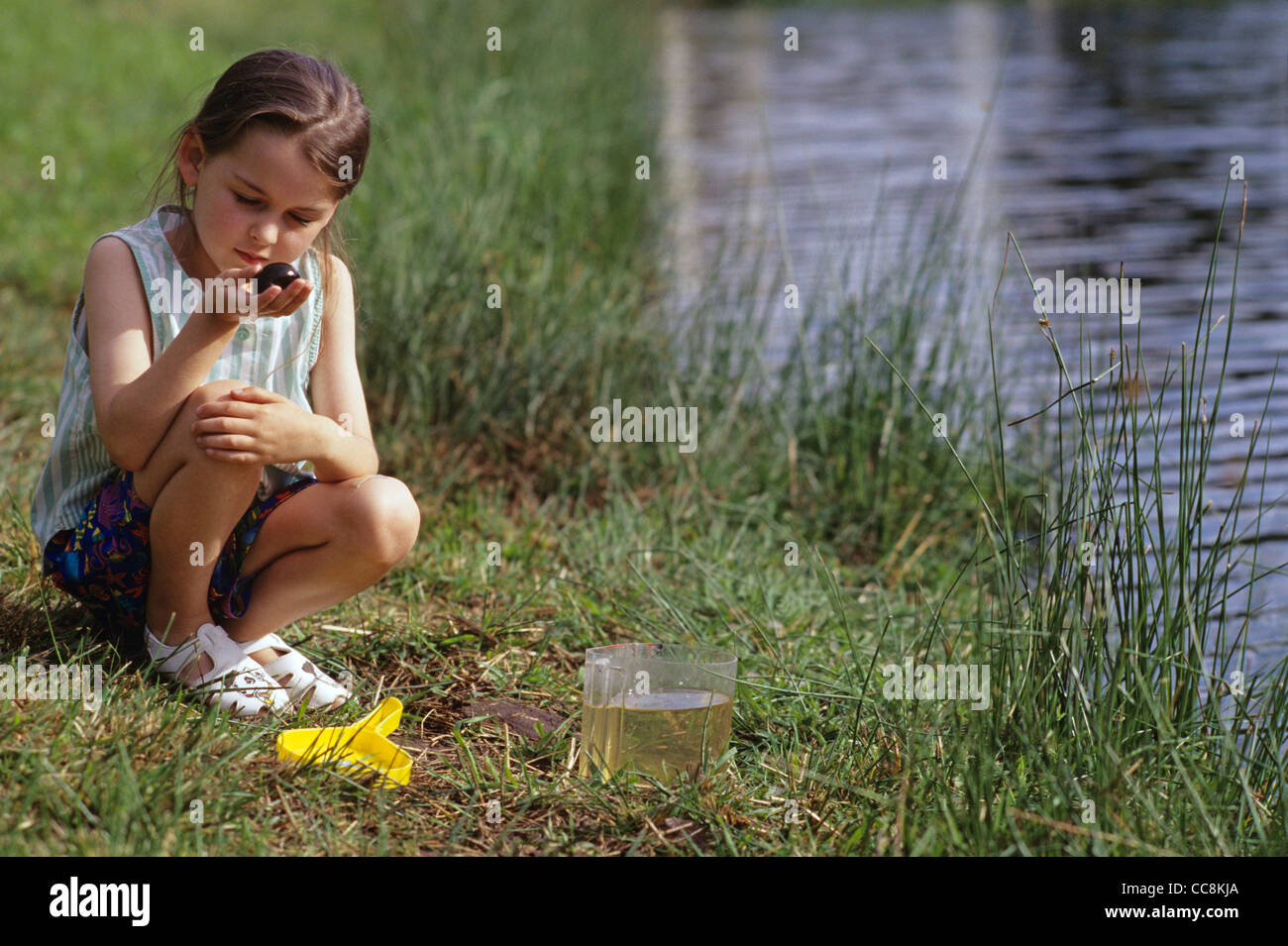 Young girl observing snail in her hands Stock Photo - Alamy