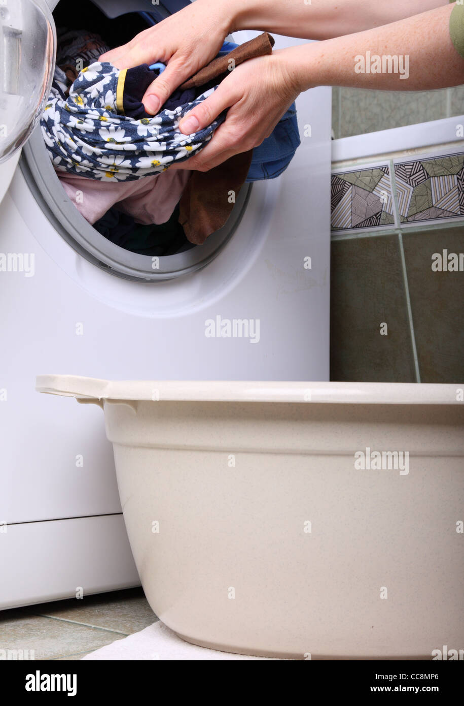 Woman loading washing machine tired hi-res stock photography and images ...
