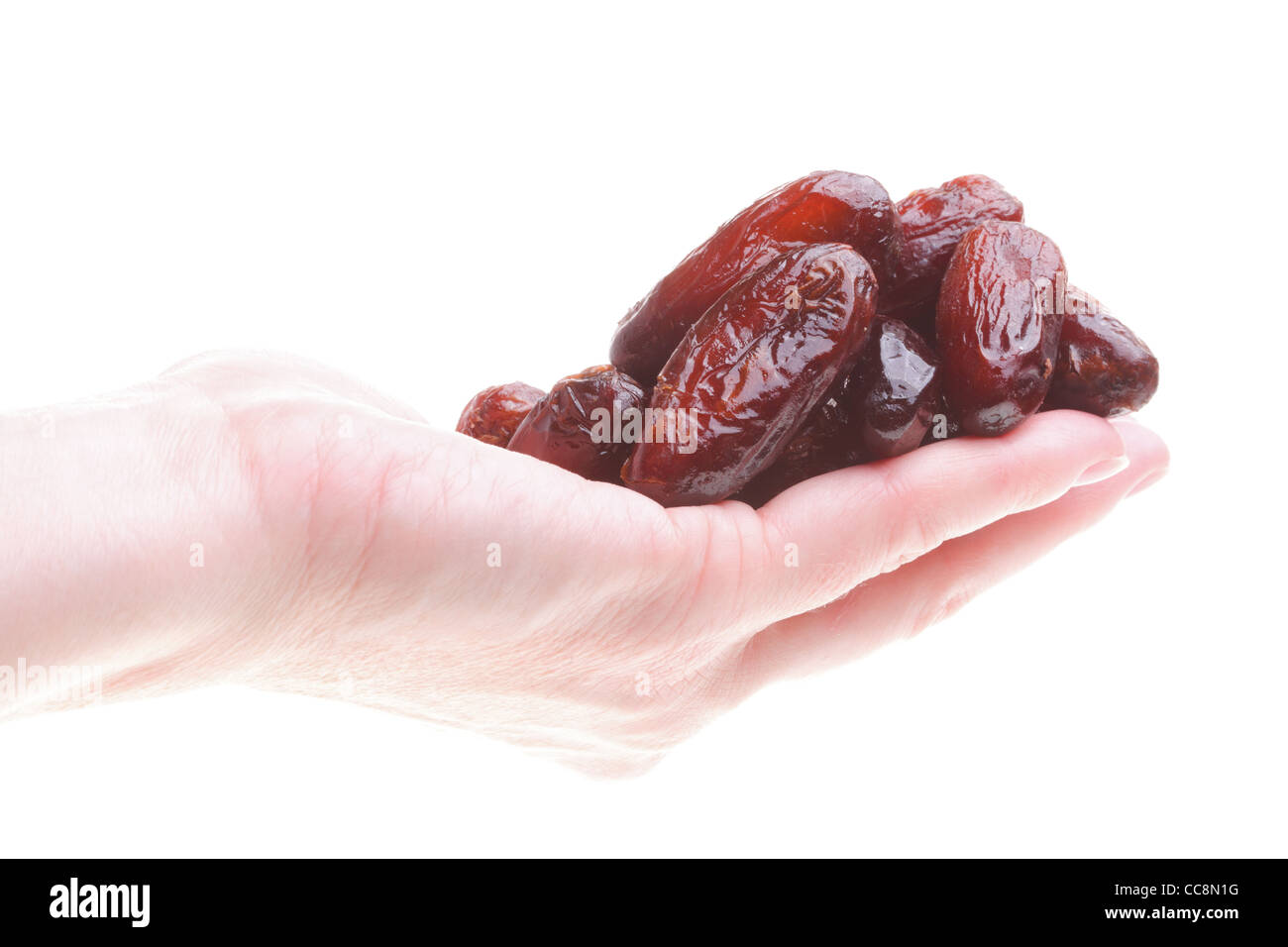Dried date fruits in hand isolated on white background Stock Photo - Alamy