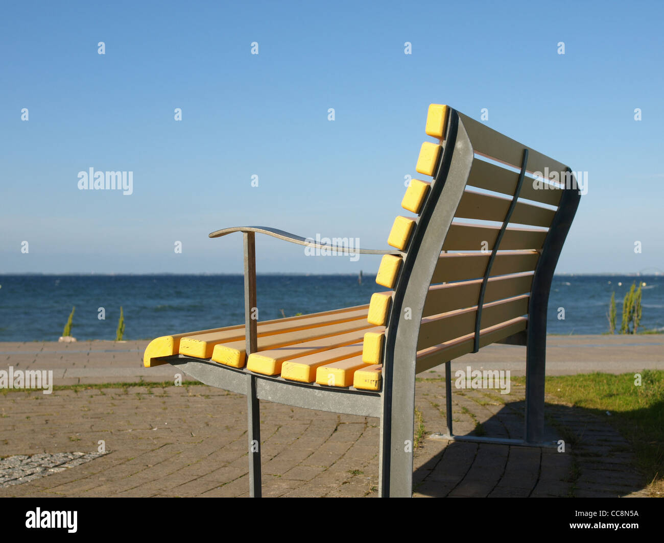 Yellow bench in front of the blue ocean Stock Photo - Alamy