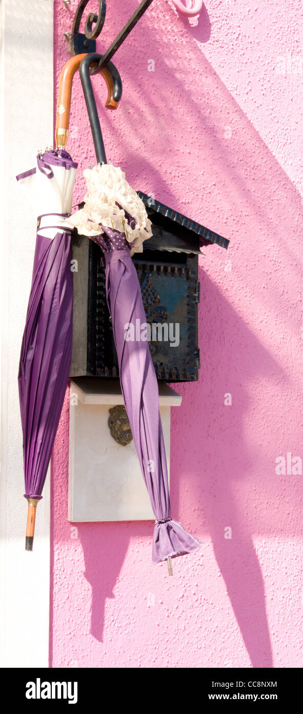 2 parasols and a postbox on a pink painted house in Burano, Italy Stock ...