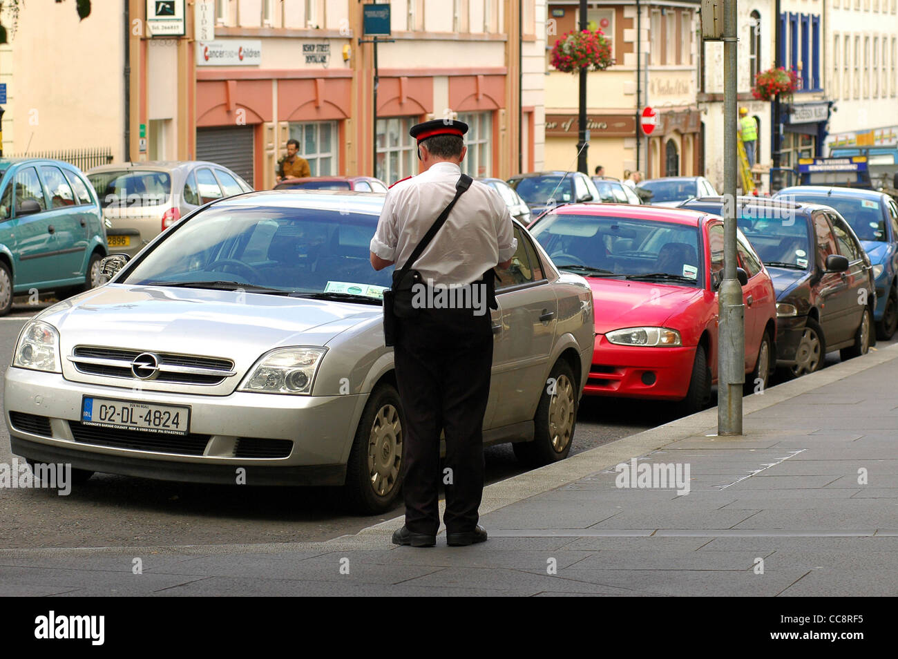 Traffic warden issuing a ticket for a parking offence, Londonderry ...