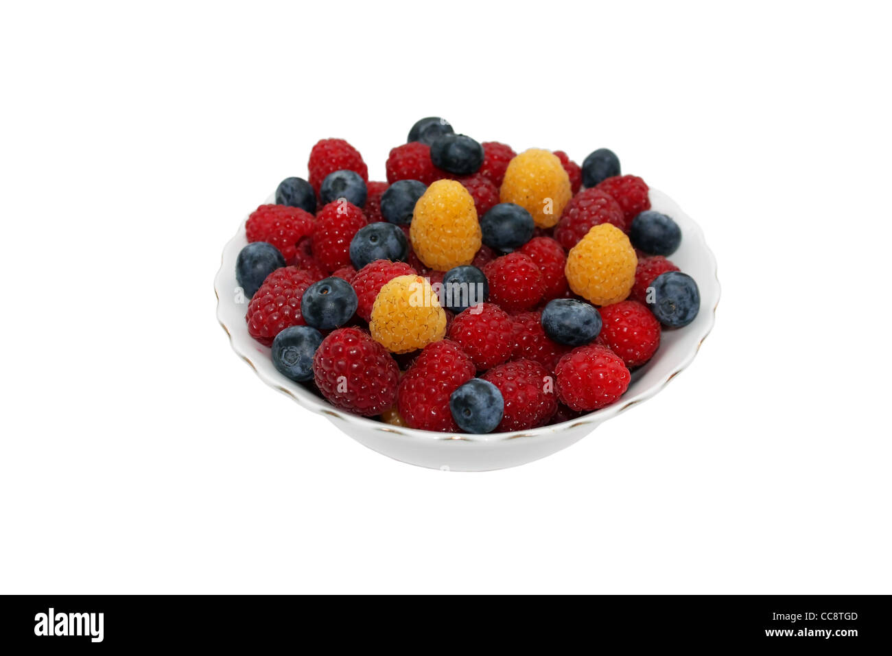 Red and yellow raspberries and blueberries in the bowl, isolated Stock ...