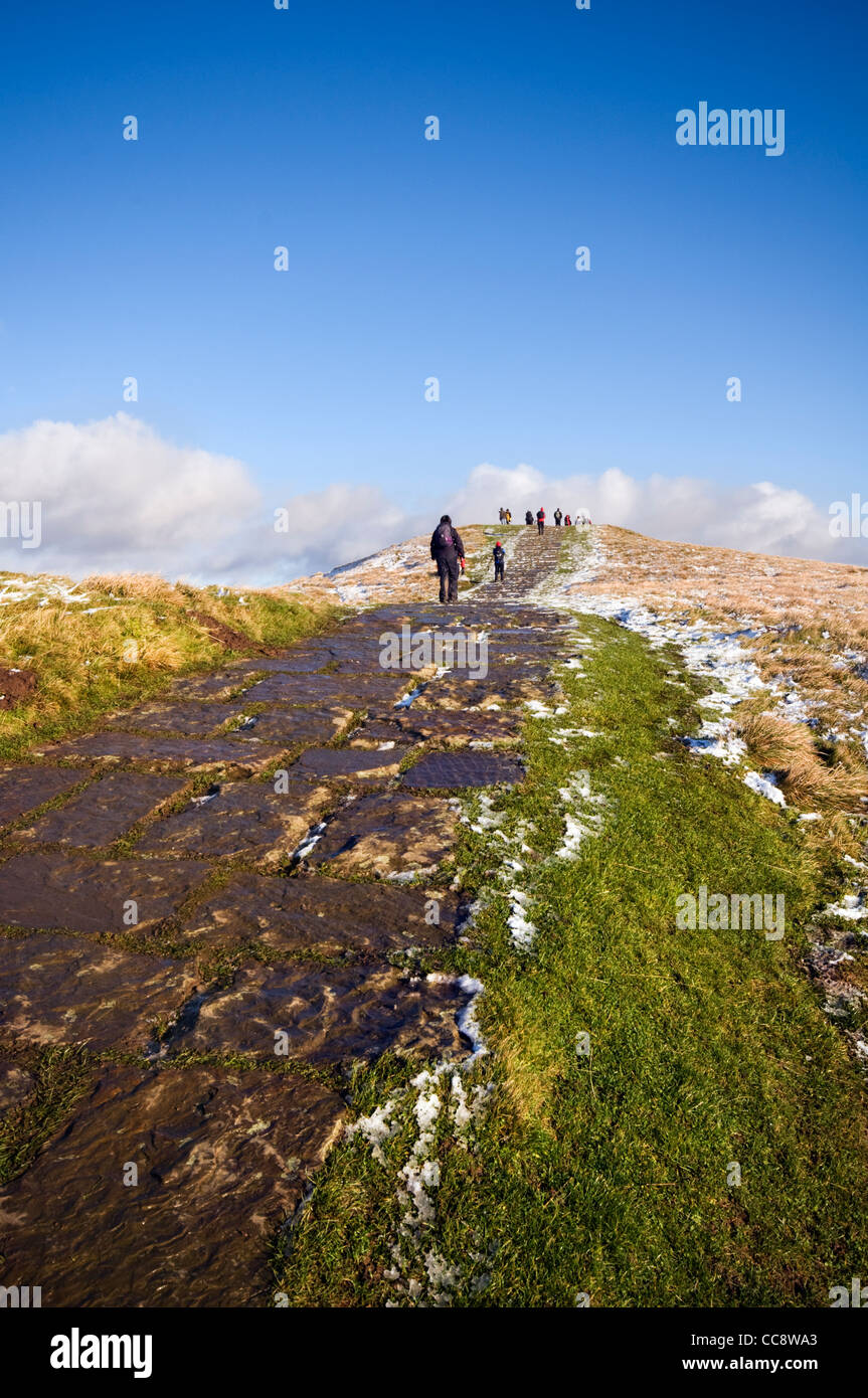 Winter hikers walking to the top of Mam Tor in the Peak District ...