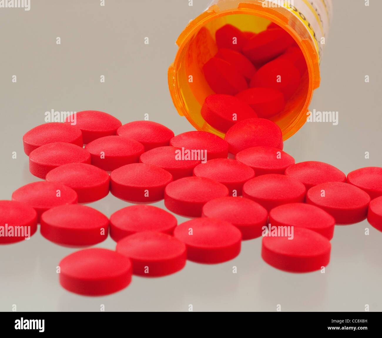 bottle tipped on side with red pills Stock Photo - Alamy