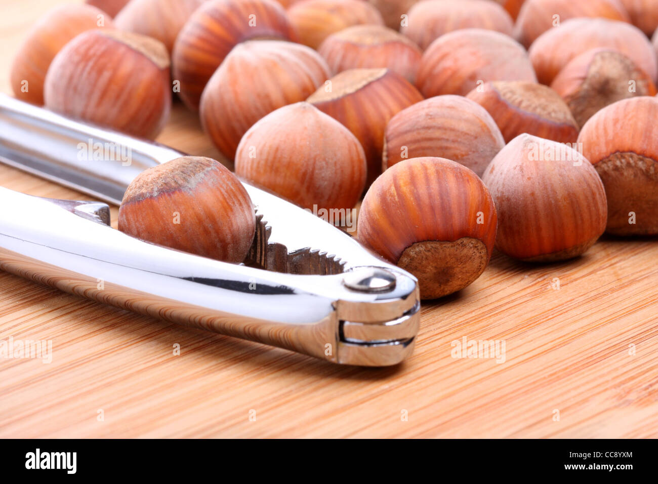 Heap of hazelnuts with nutcracker Stock Photo - Alamy