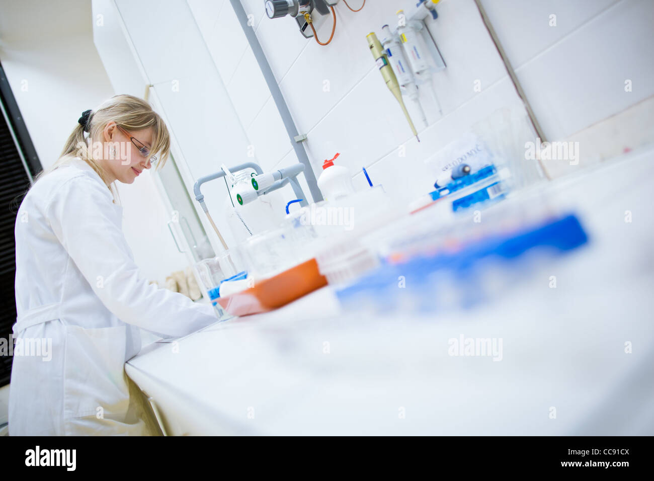female researcher carrying out research experiments in a chemistry lab ...