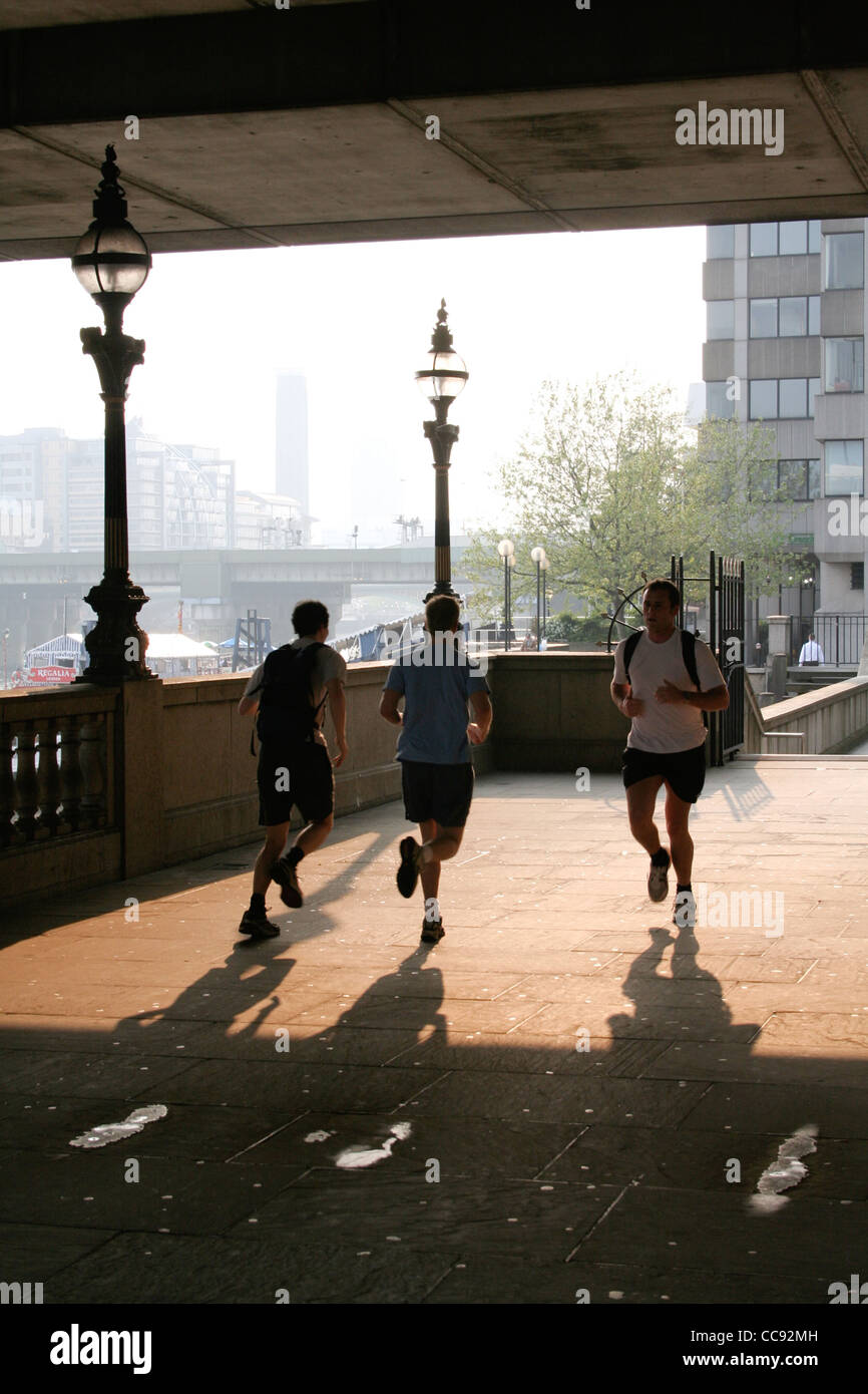 Joggers along Thames footpath under London Bridge Stock Photo - Alamy