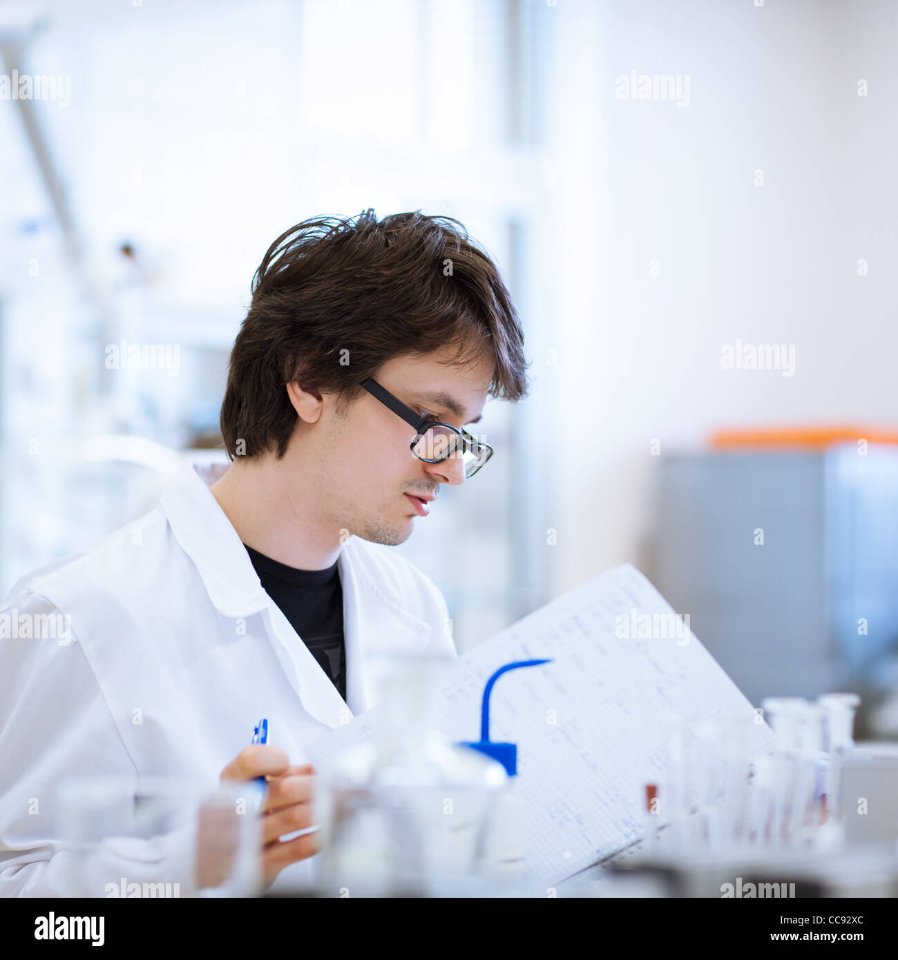 young, male researcher/chemistry student carrying out scientific ...