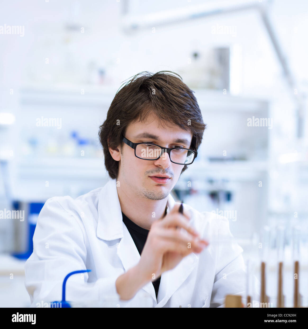 young, male researcher/chemistry student carrying out scientific ...