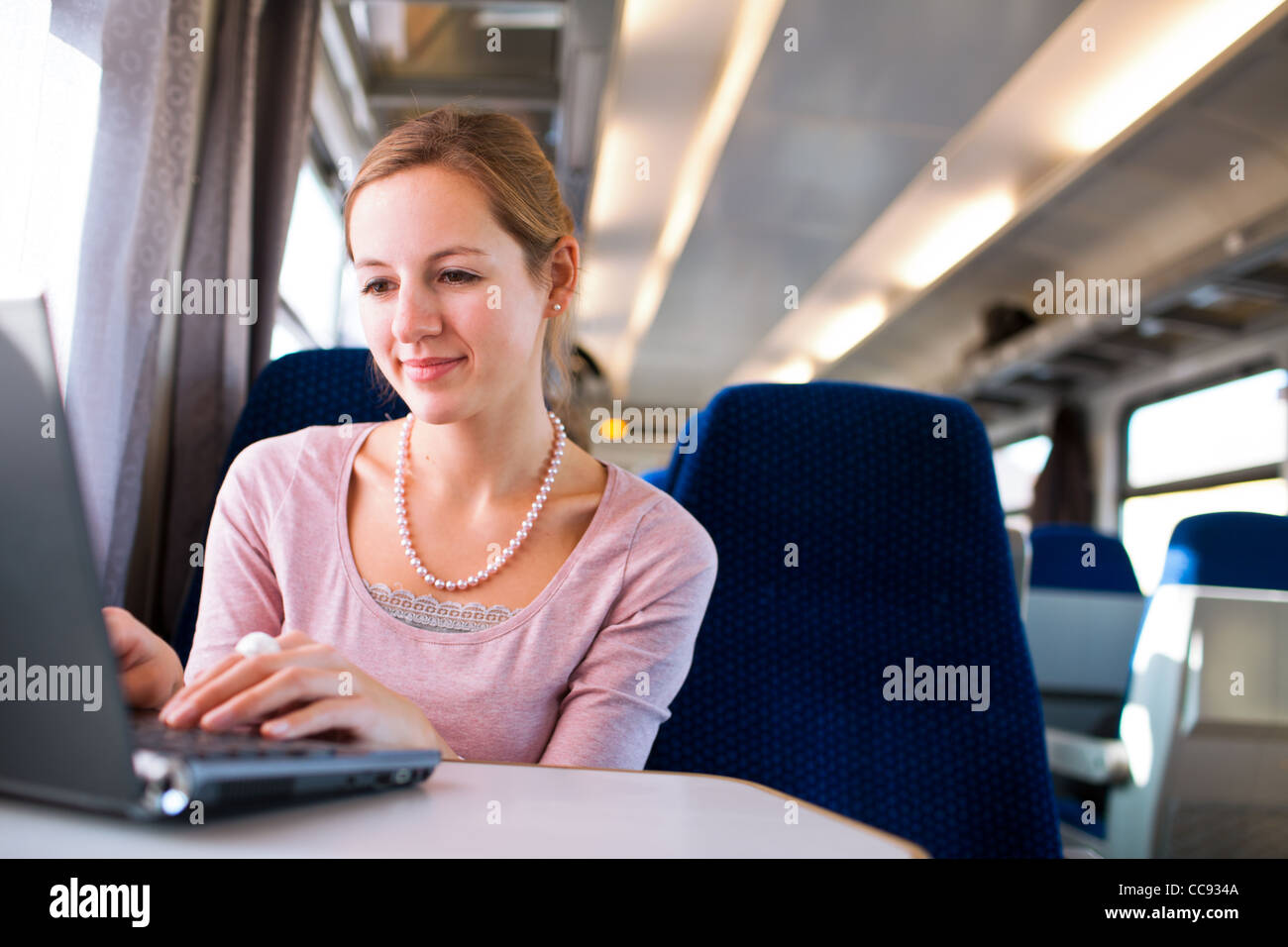 Young woman using her laptop computer while traveling by train Stock ...