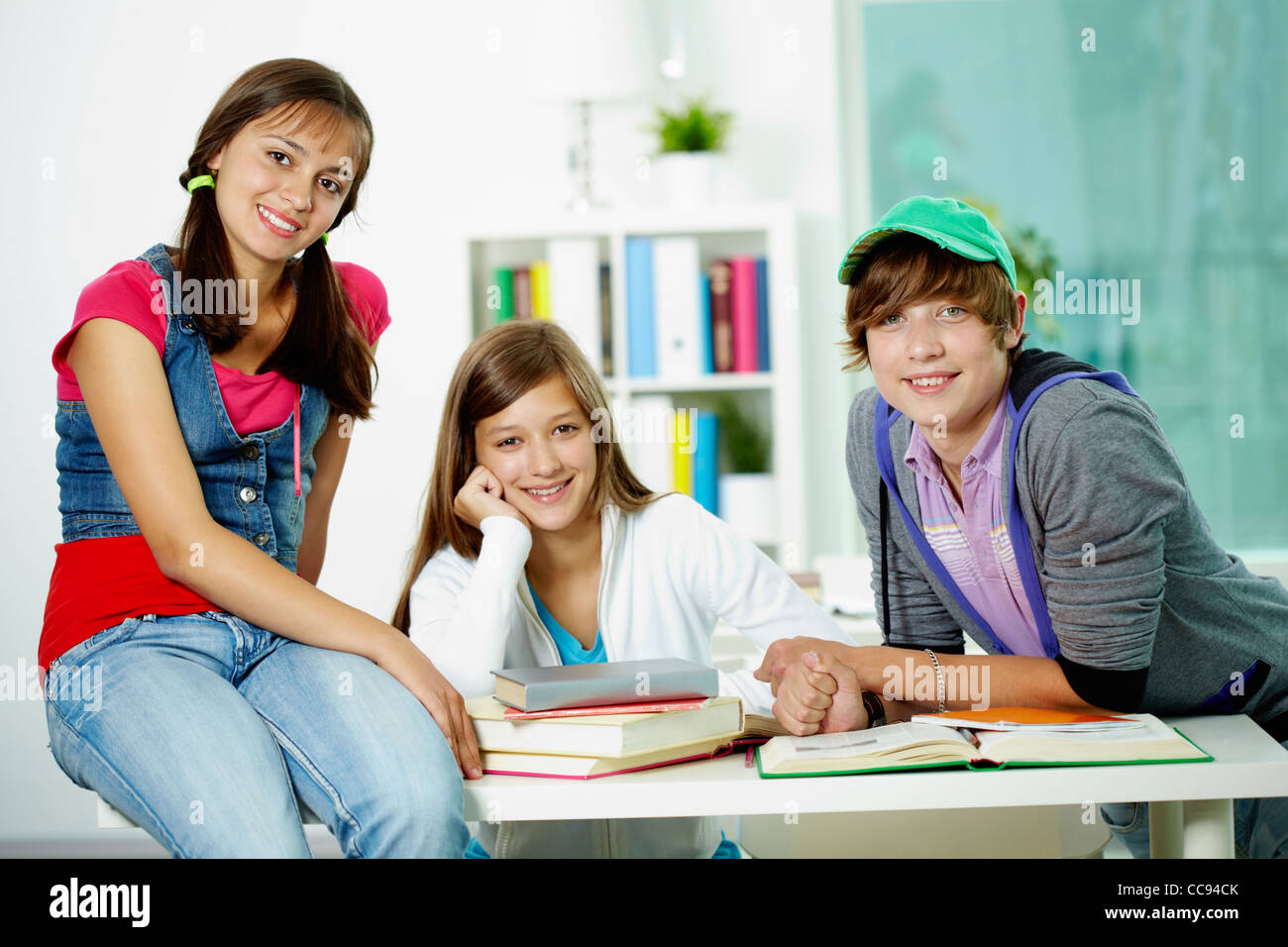 Portrait of three smart classmates looking at camera in classroom Stock ...