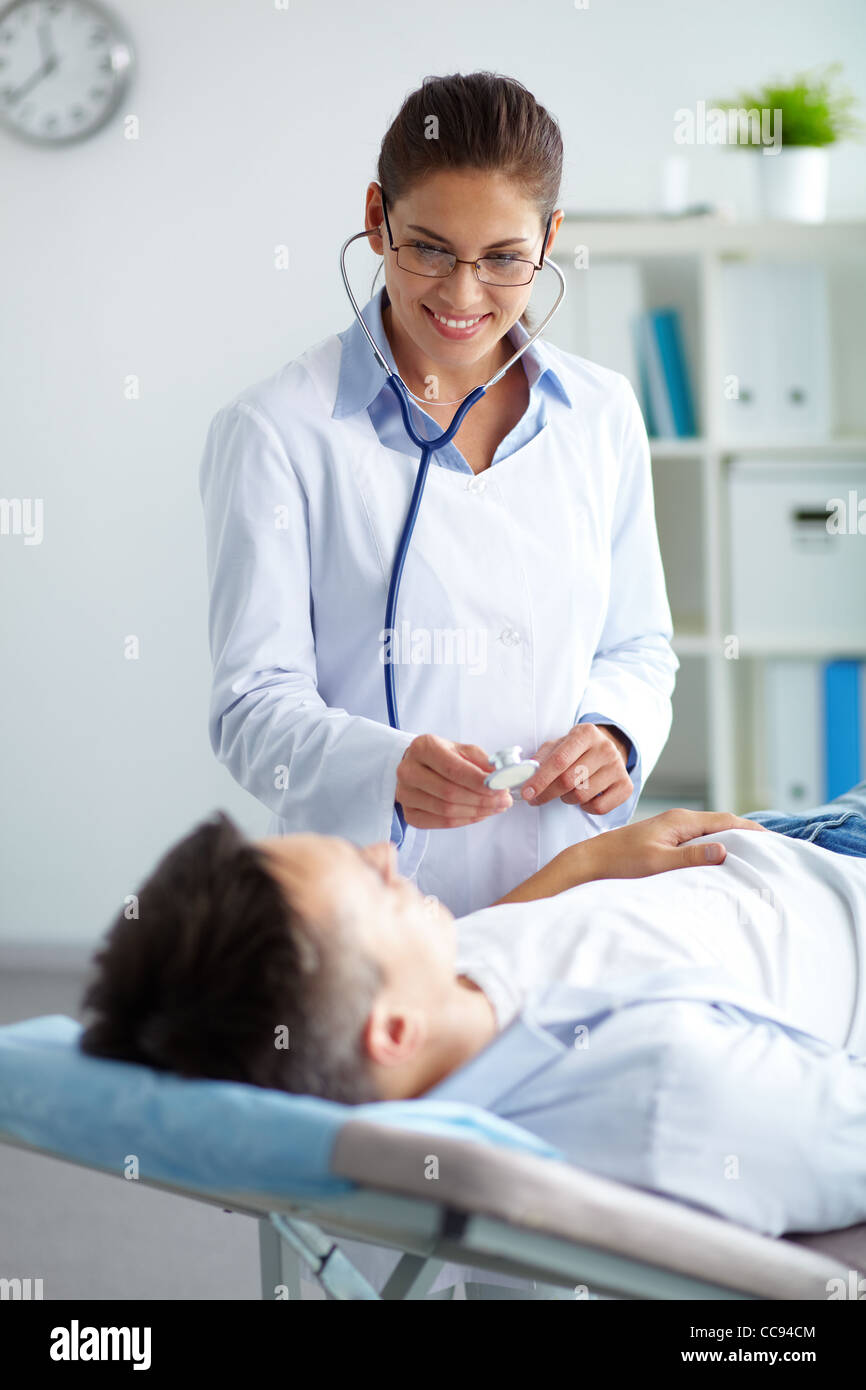 Portrait of confident female doctor looking at patient during medical ...