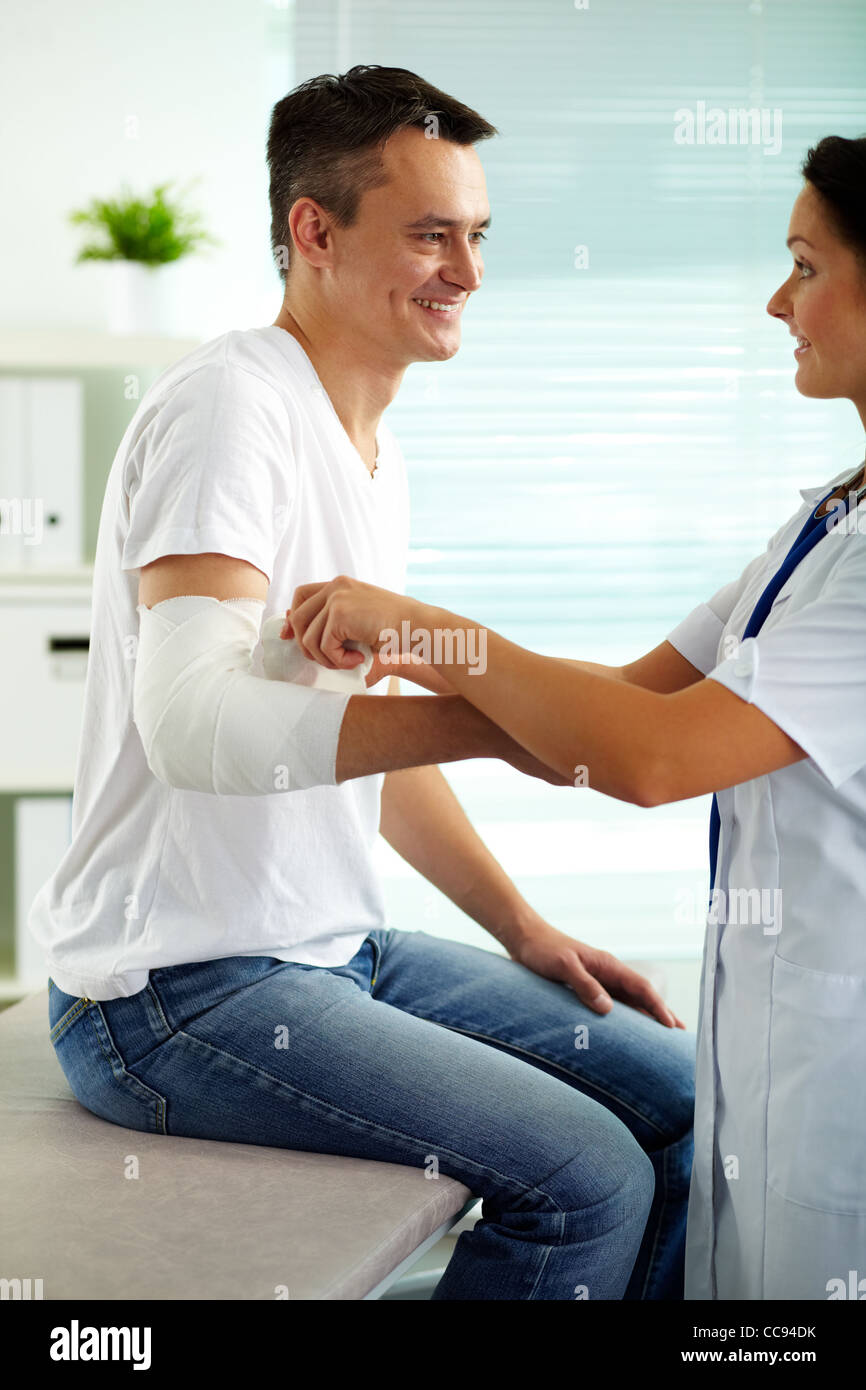 Portrait of pretty female doctor giving first aid to patient in ...
