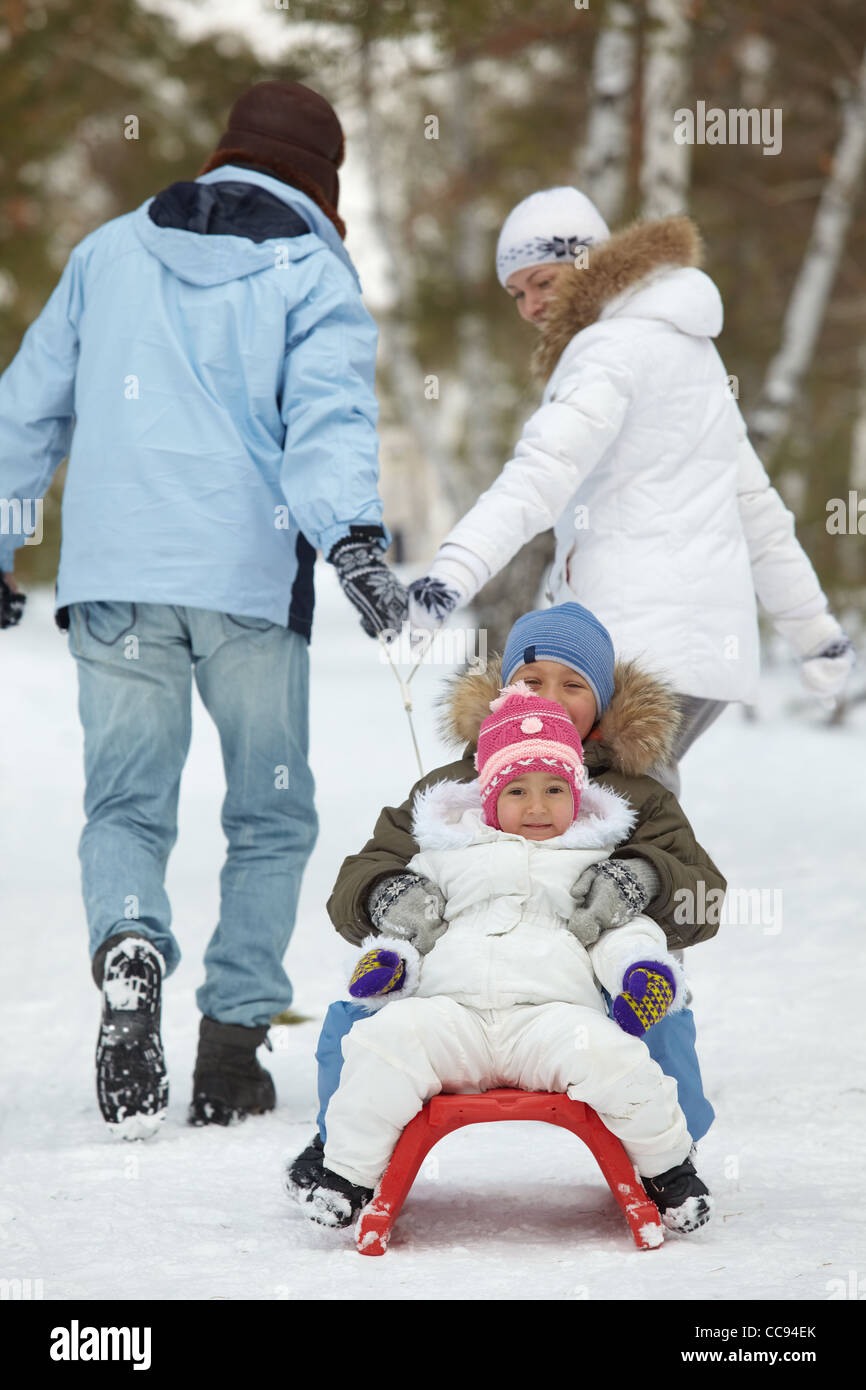 Image of parents riding their kids on sledge in park Stock Photo - Alamy